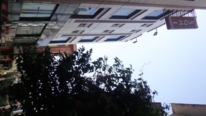 Um hotel com vários andares, janelas amplas e uma placa indicando que é um hotel.
