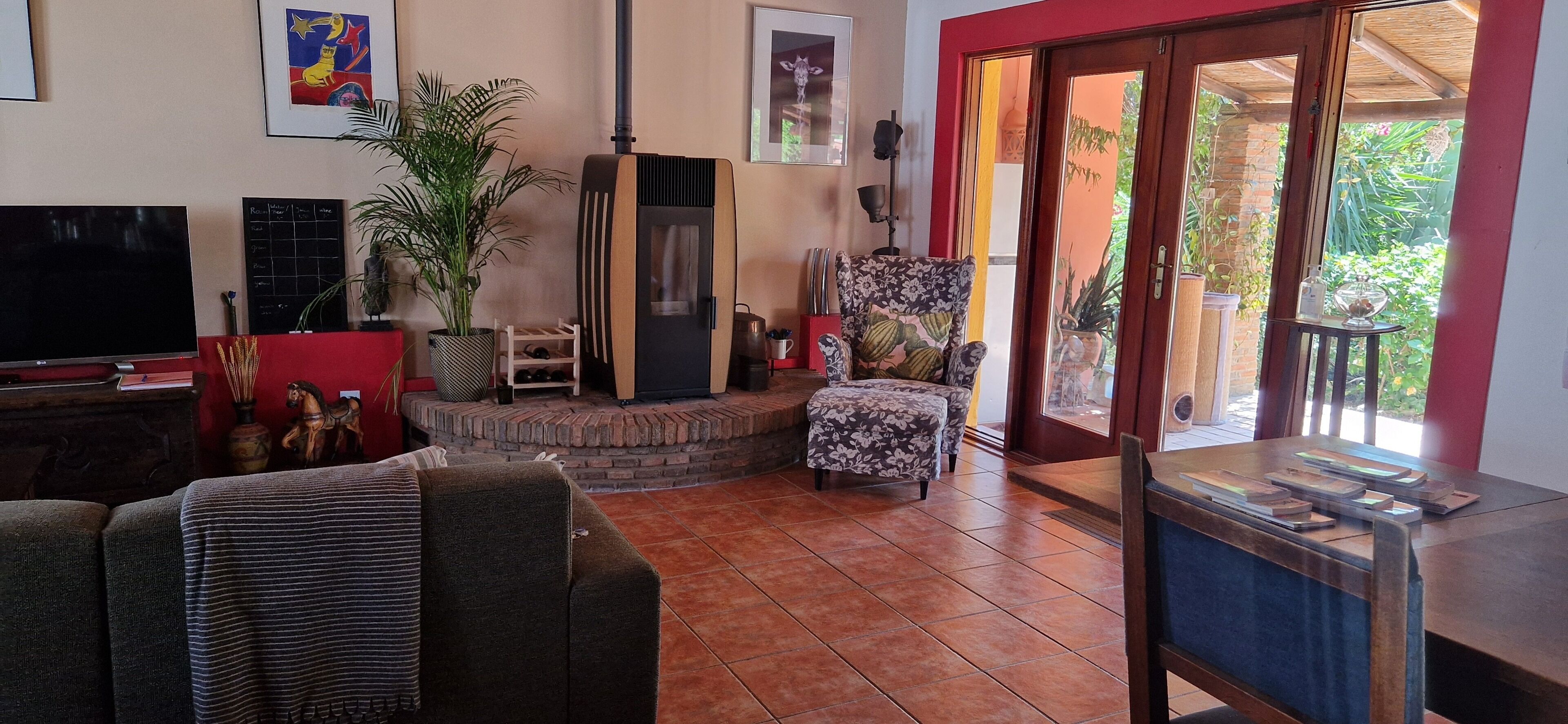 Uma sala de estar com lareira, televisão e um espaço de jantar com mesa e cadeiras.