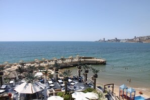 Praia particular, espreguiçadeiras, guarda-sóis, toalhas de praia 