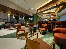 Uma área de bar moderna com assentos e uma tela de televisão.