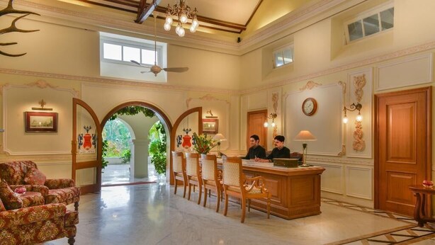 Um hall amplo com balcão de recepção, área de estar e vista para o exterior.