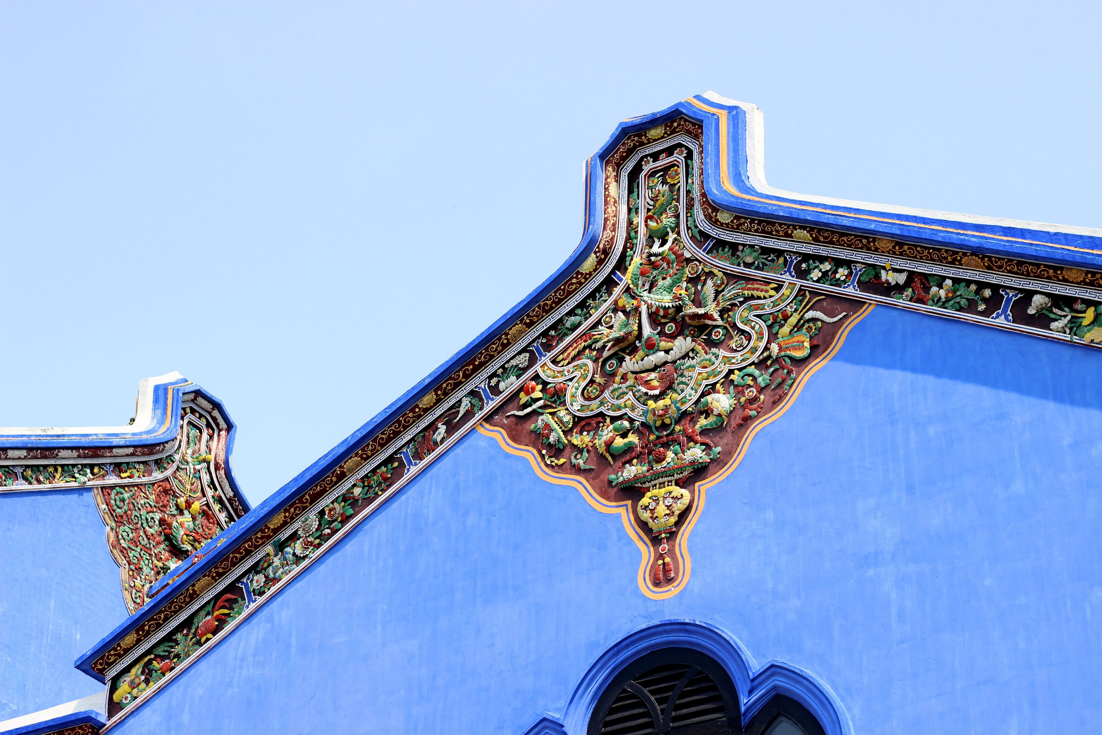 Um edifício com fachada azul e detalhes arquitetônicos coloridos e elaborados.