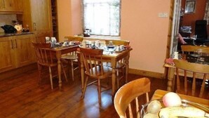 Uma área de jantar com mobiliário de madeira e uma mesa posta para quatro pessoas.