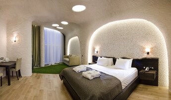 Quarto de hotel moderno com uma cama grande, uma escrivaninha e um espaço de estar.