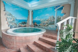 Área de hidromassagem com um mural de paisagem costeira, degraus de acesso e uma escada com corrimão.
