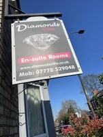 Placa anunciando quartos privativos em 'Diamonds Villa'.