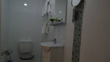 Um banheiro pequeno e moderno, com vaso sanitário, pia e espelho.