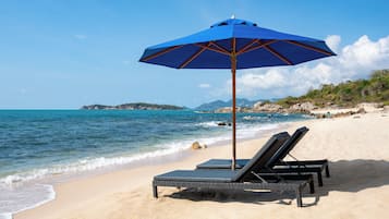 Praia particular, areia branca, espreguiçadeiras, guarda-sóis