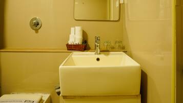 Um chuveiro fixo, roupões, chinelos, toalhas fornecidas