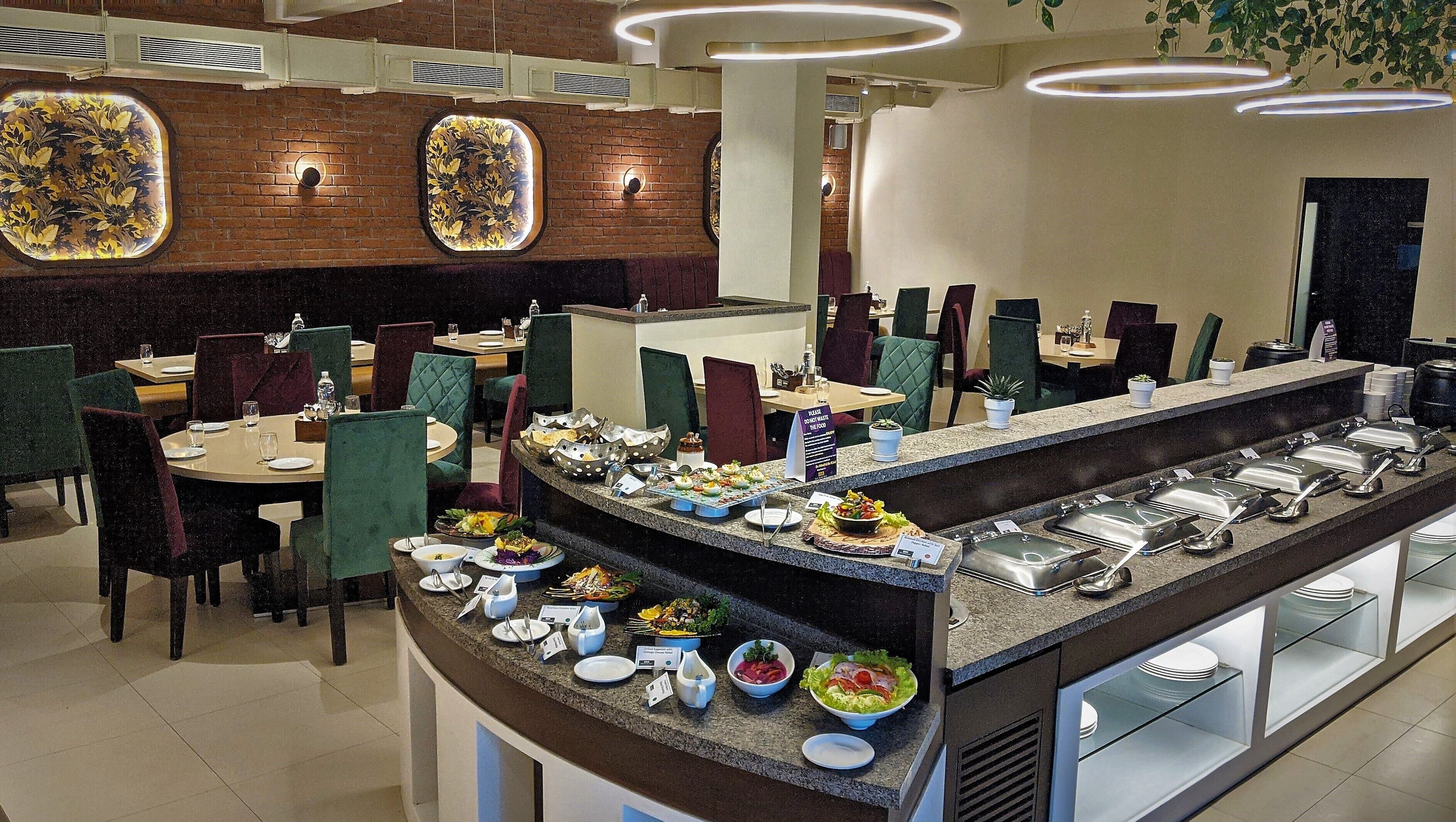 Espaço de café da manhã estilo buffet com diversas opções de comida e um serviço de autoatendimento.