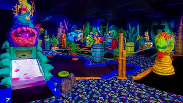 Uma área de recreação vibrante e coberta, com diversas estruturas de lazer coloridas e um piso estampado.