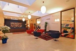 Um hall moderno com balcão de recepção, área de estar e obras de arte nas paredes.
