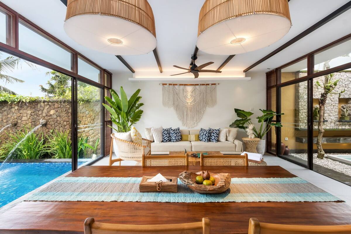 Uma sala de estar moderna com piscina, janelas amplas e ventilador de teto.