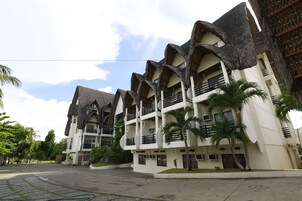 Um hotel de vários andares com um design arquitetônico único, com varandas curvas e um pátio central.
