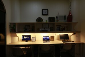 Uma escrivaninha com dois monitores, um laptop e um teclado. Há duas cadeiras à frente da escrivaninha.