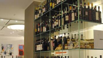 Uma adega com várias prateleiras de vidro repletas de diferentes garrafas de vinho.