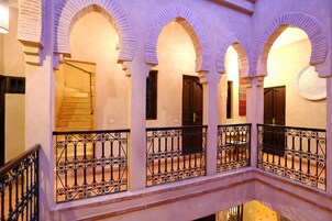 Um edifício com várias arcos e varandas com grades de ferro forjado.