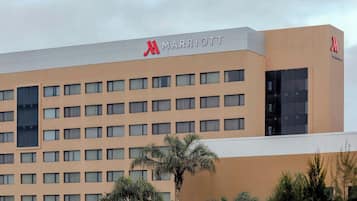 Um edifício de vários andares com o logotipo da Marriott, apresentando um design arquitetônico moderno com telhado plano e várias janelas.