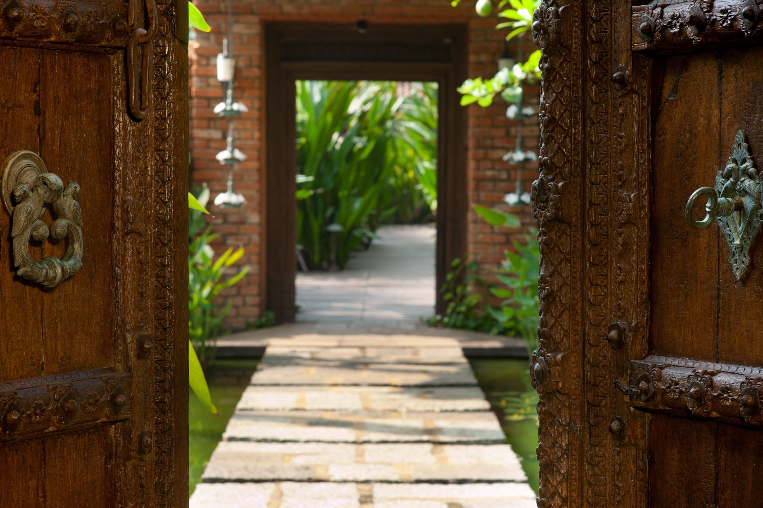Uma porta de madeira com esculturas detalhadas e maçaneta de metal.