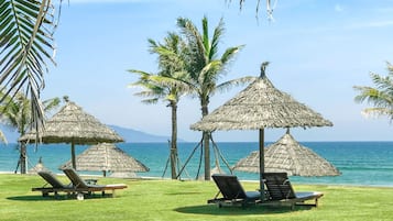 Praia particular, areia branca, espreguiçadeiras, guarda-sóis