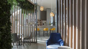 Um interior moderno com área de bar, assentos e luz natural.