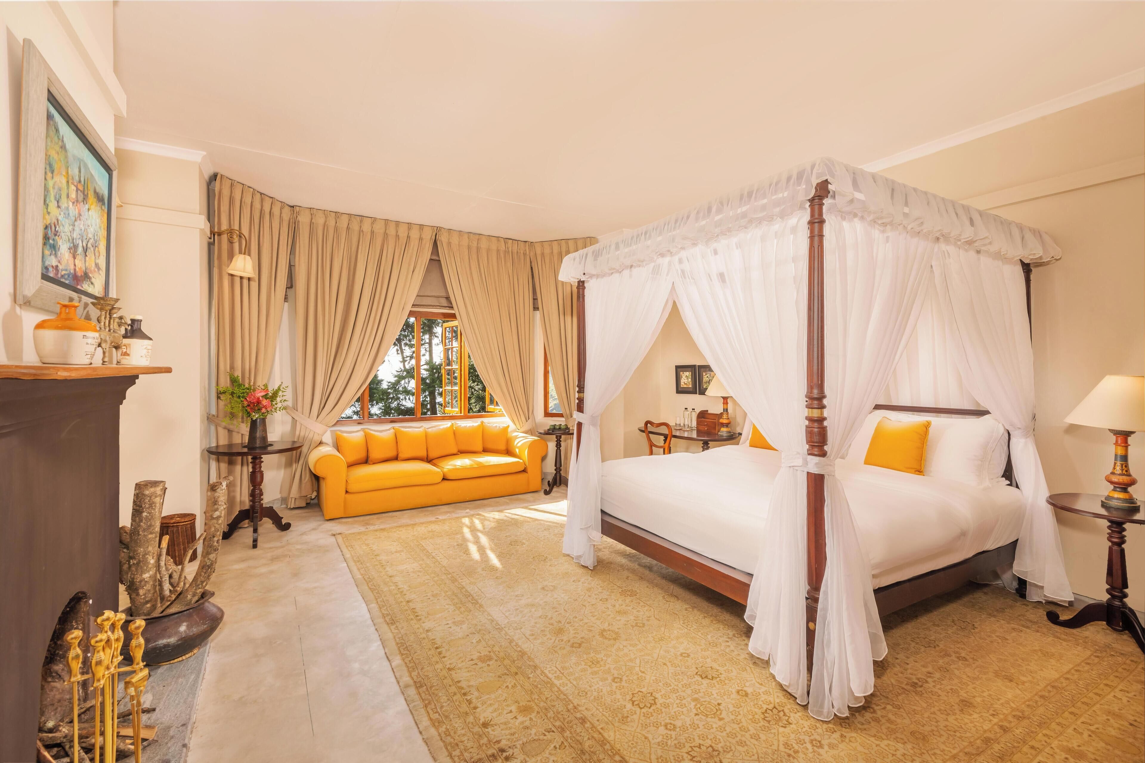 Um quarto espaçoso com uma cama de dossel, um sofá amarelo e uma grande janela com vista para o exterior.