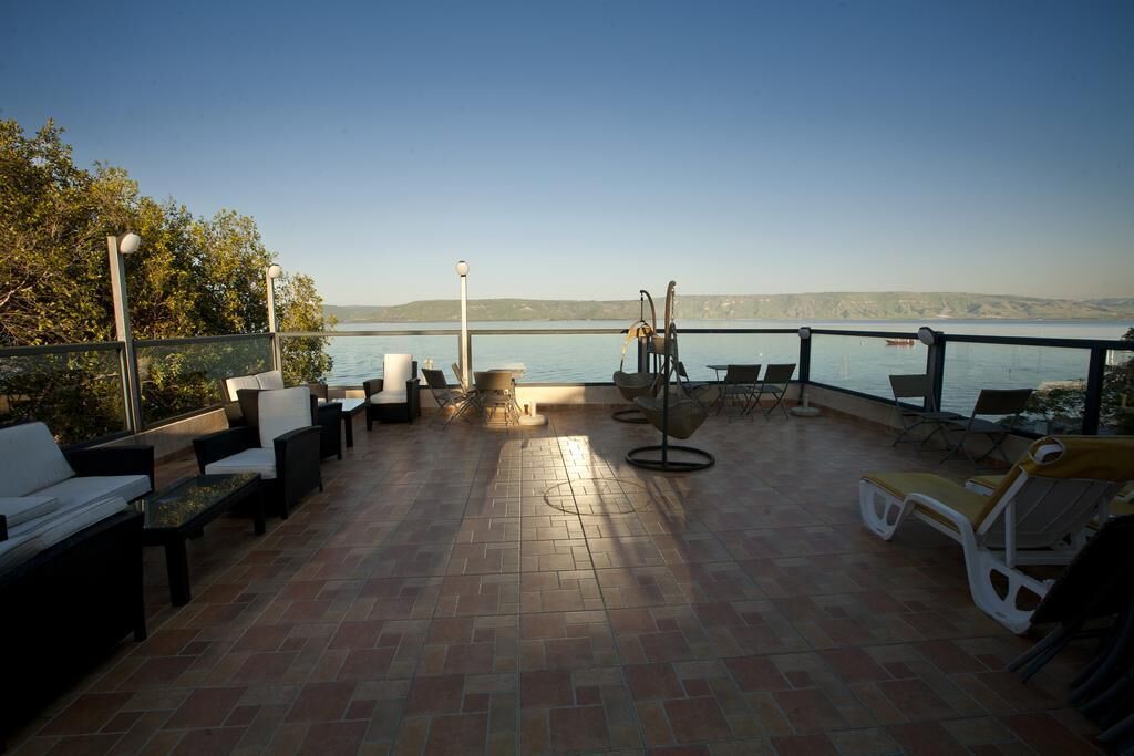 Um terraço com área de estar ao ar livre, uma mesa e vista para o mar.