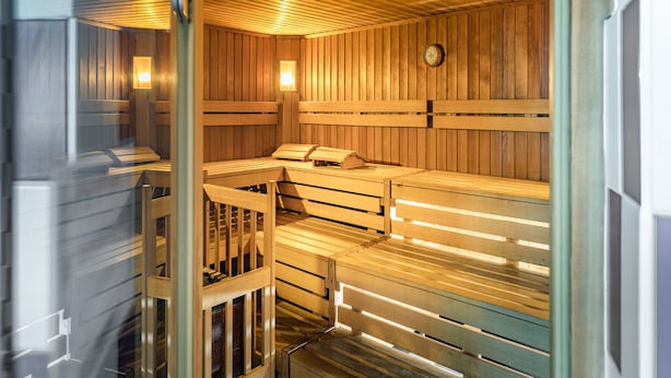 Uma sauna com bancos de madeira e um relógio na parede.
