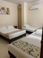 Quarto de hotel com duas camas, um quadro na parede, uma janela com cortinas e um aparelho de ar condicionado.