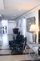 Uma sala moderna com um sofá, uma parede decorativa e uma mesa com abajur.