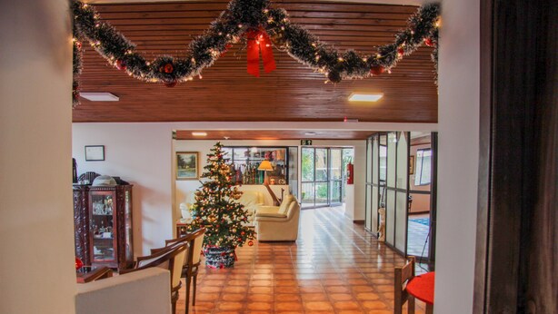 Um corredor com árvore de Natal, teto de madeira e piso de azulejos.