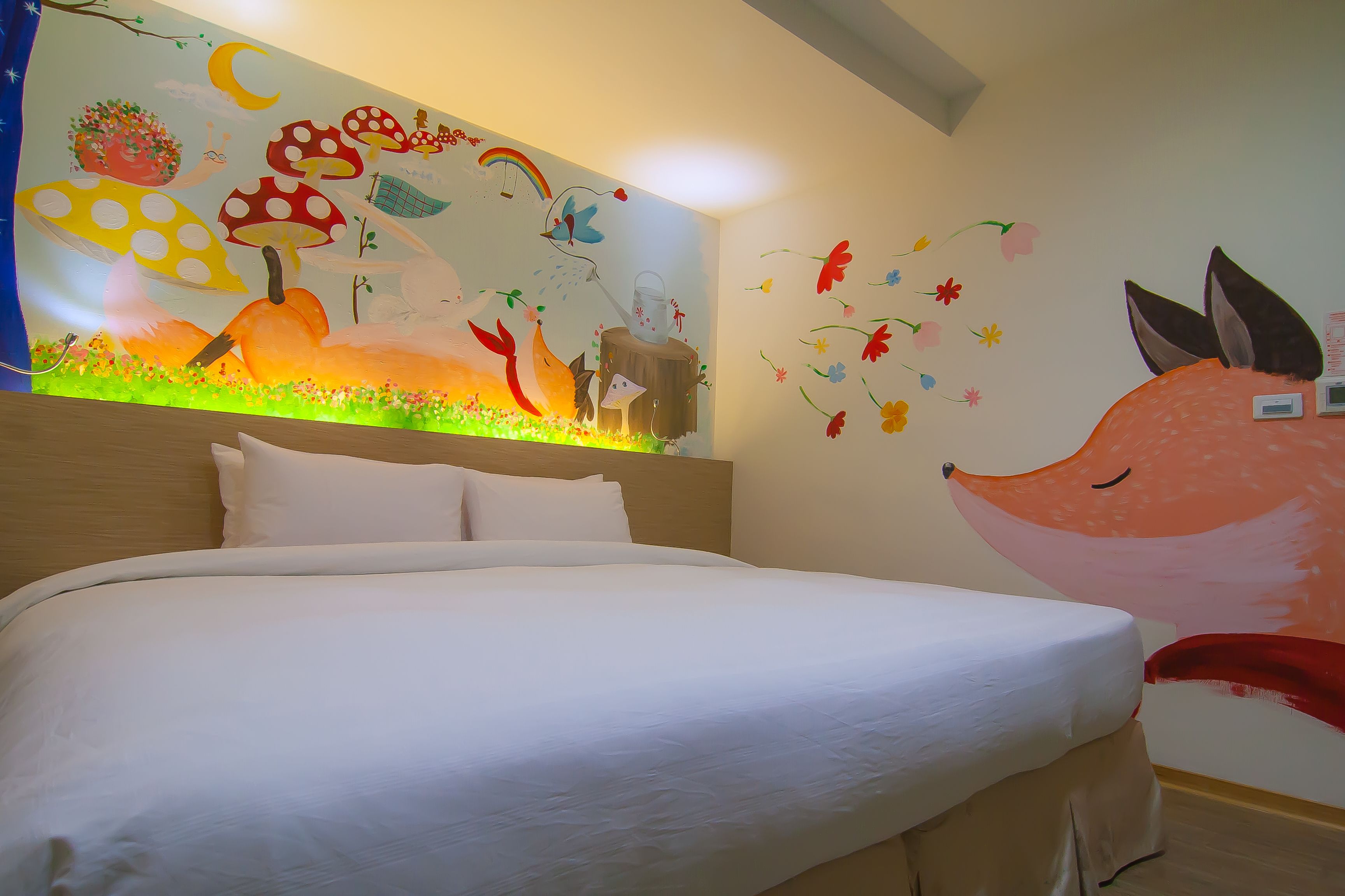 Quarto com uma cama grande, um mural na parede e uma decoração com raposa.
