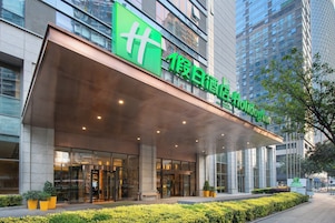 Um edifício moderno com uma grande placa verde para Holiday Inn.