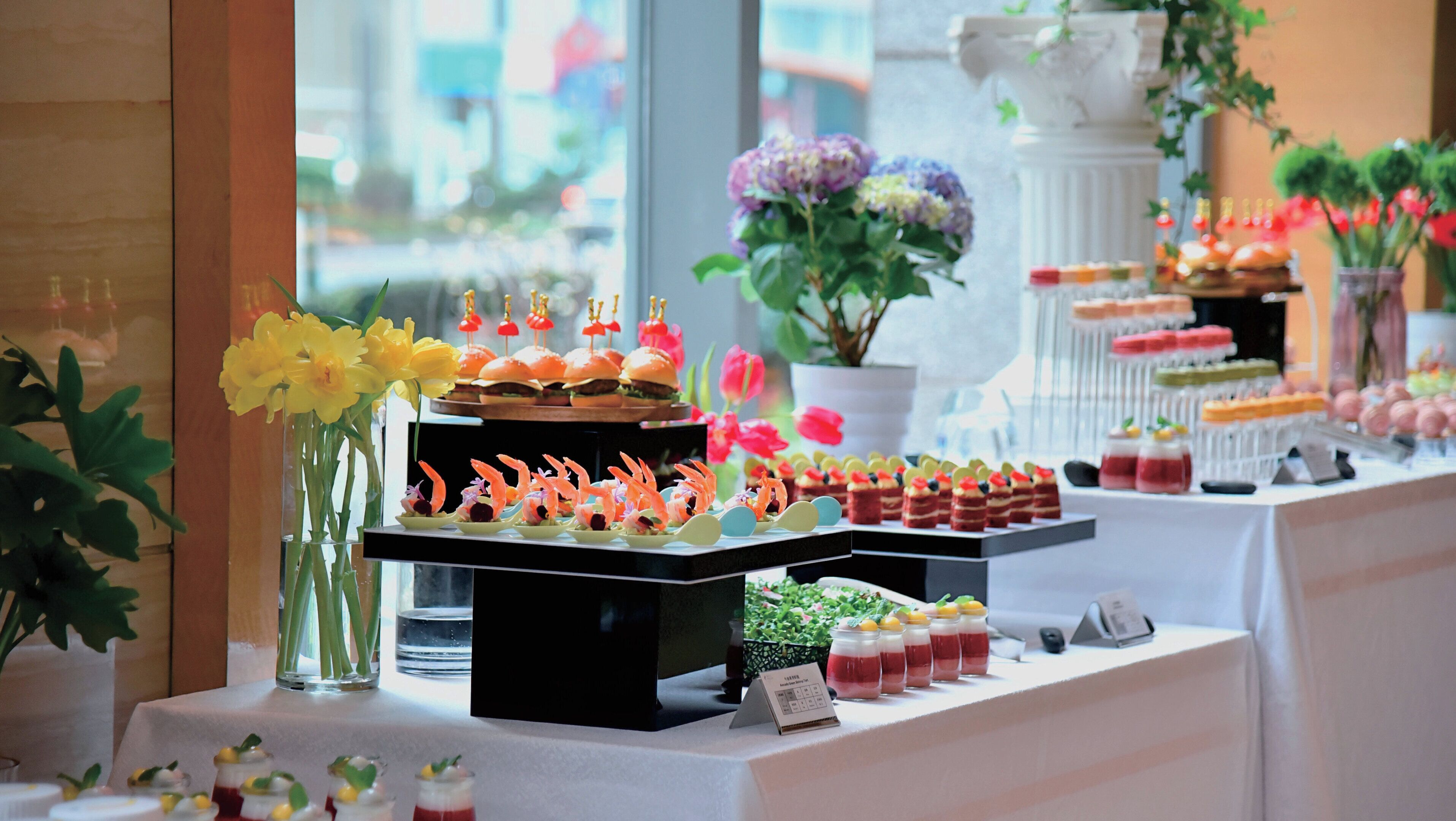 Mesa de buffet com diversos alimentos e decorações.