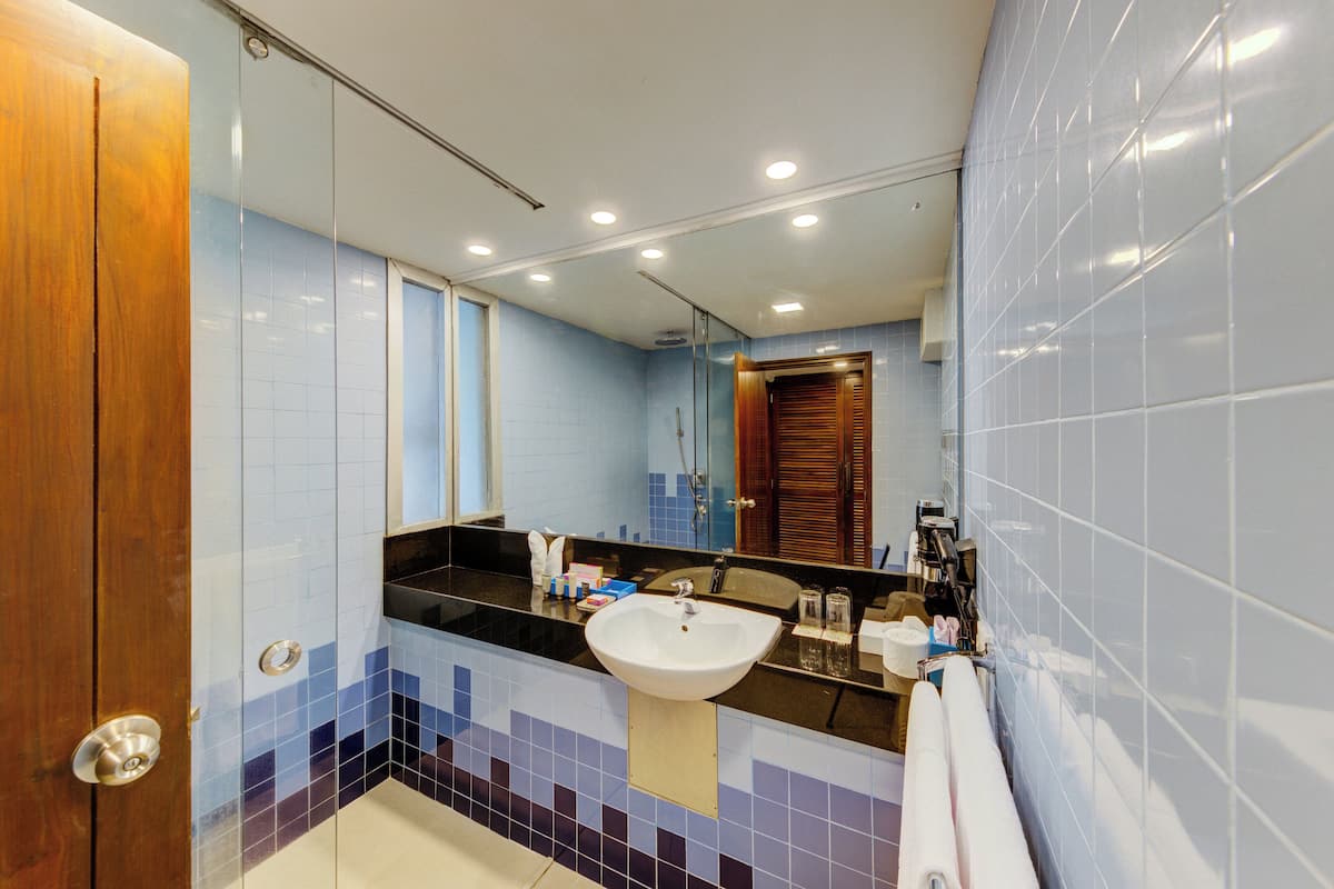 Uma casa de banho moderna com uma grande pia, um espelho e zona de duche.