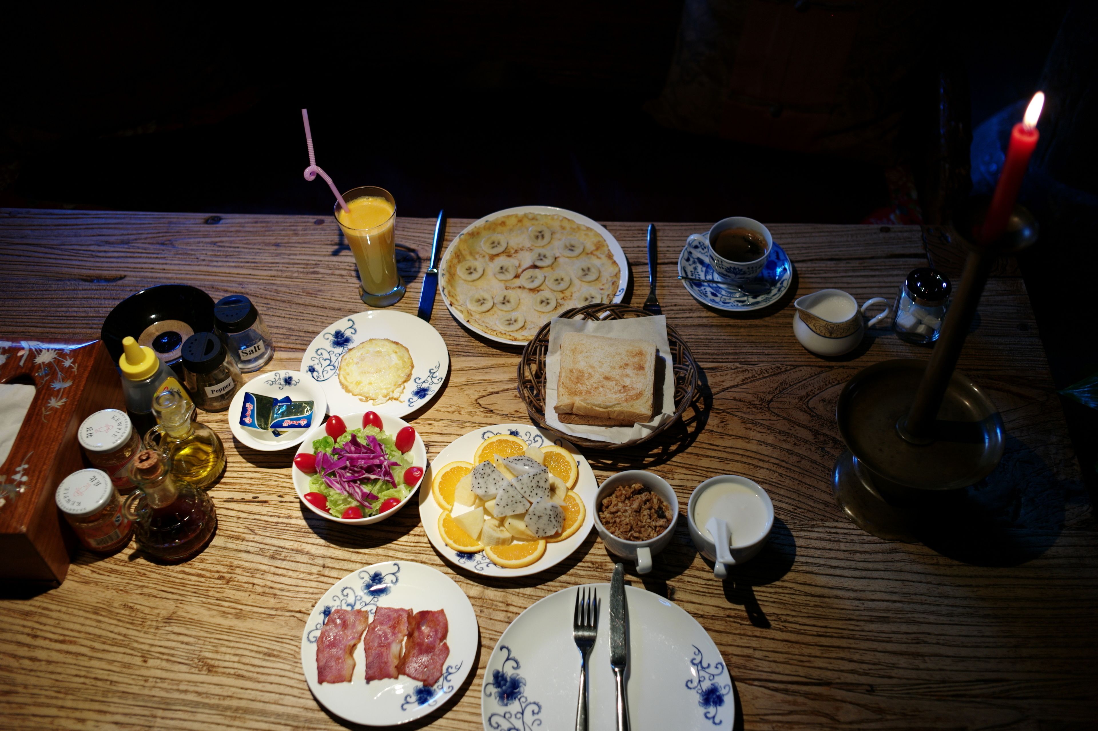 Uma mesa de madeira com itens de café da manhã, incluindo ovos, torradas e frutas.