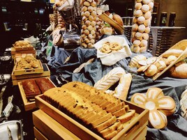 Vitrine de uma padaria com diversos pães e doces.
