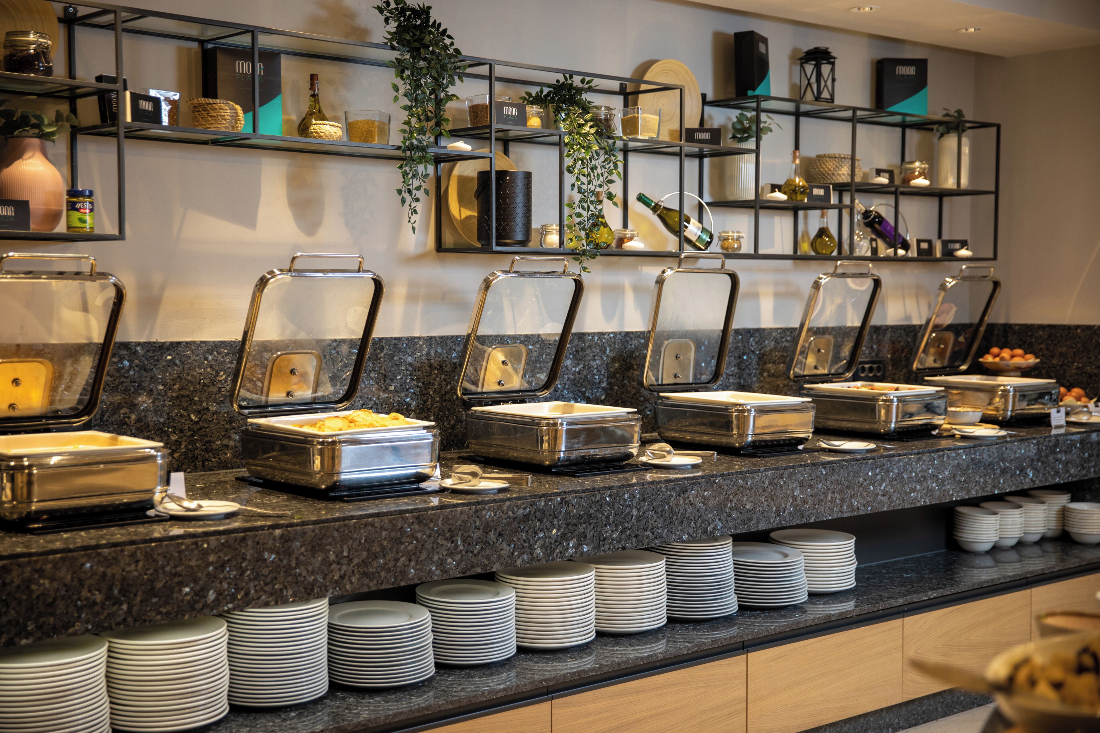 Disposição de buffet com várias estações de serviço, cada uma com tampa de vidro e puxadores de metal.