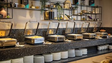 Disposição de buffet com várias estações de serviço, cada uma com tampa de vidro e puxadores de metal.