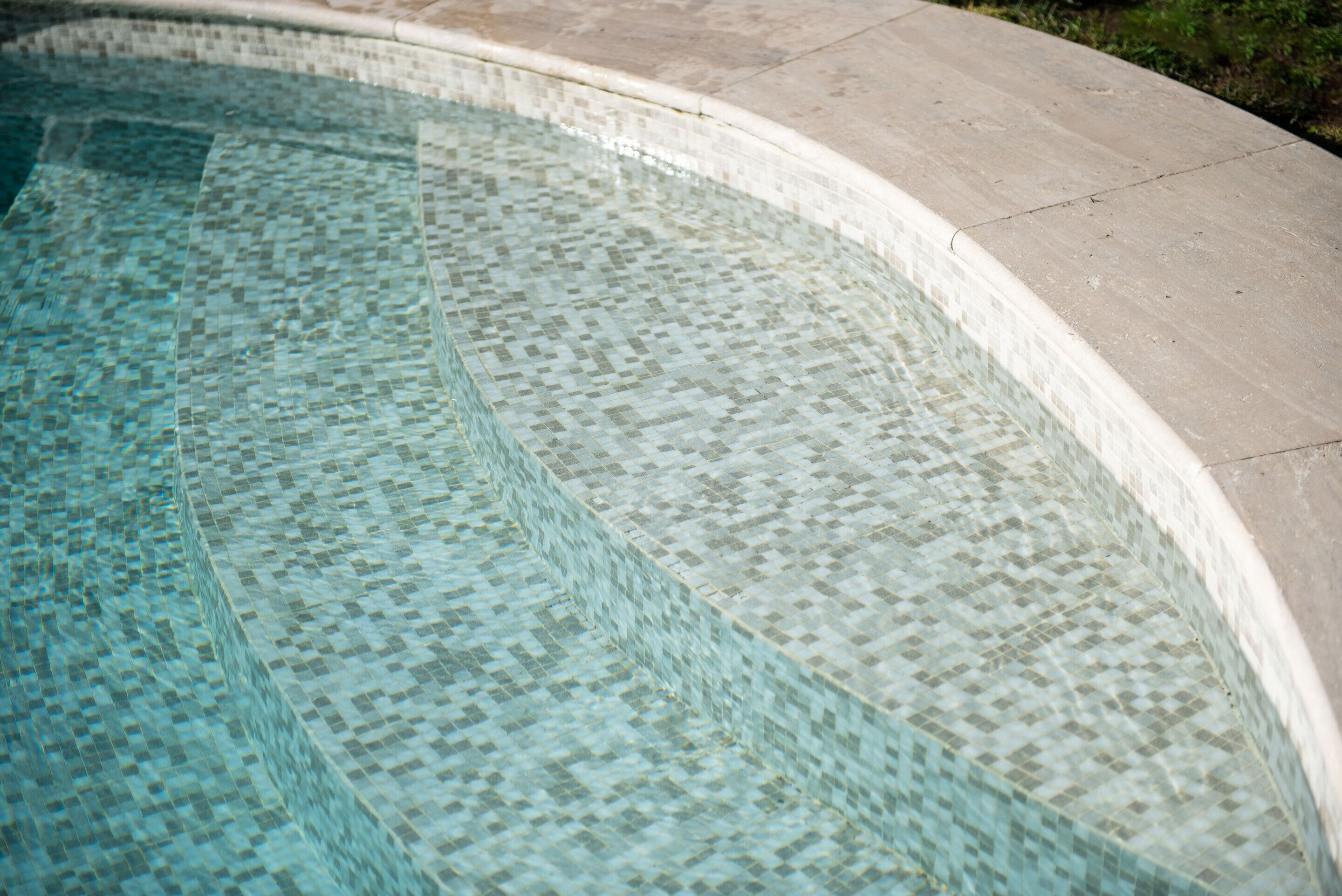 Piscina com borda revestida e design curvo.
