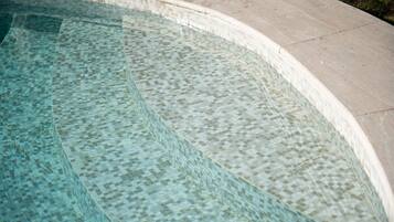 Piscina com borda revestida e design curvo.