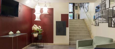 Uma sala de estar moderna com escada, televisão de tela plana e sofá verde.