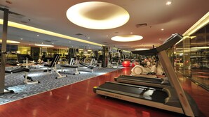Uma academia com esteiras, bolas de exercício e aparelhos de musculação.