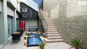Uma área externa moderna com escadas, assentos e um recurso de água.