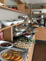 Disposição de buffet com diversos alimentos e utensílios.