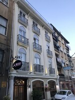 Um edifício com vários andares e uma placa com a inscrição 'MUYAN SUITES'.