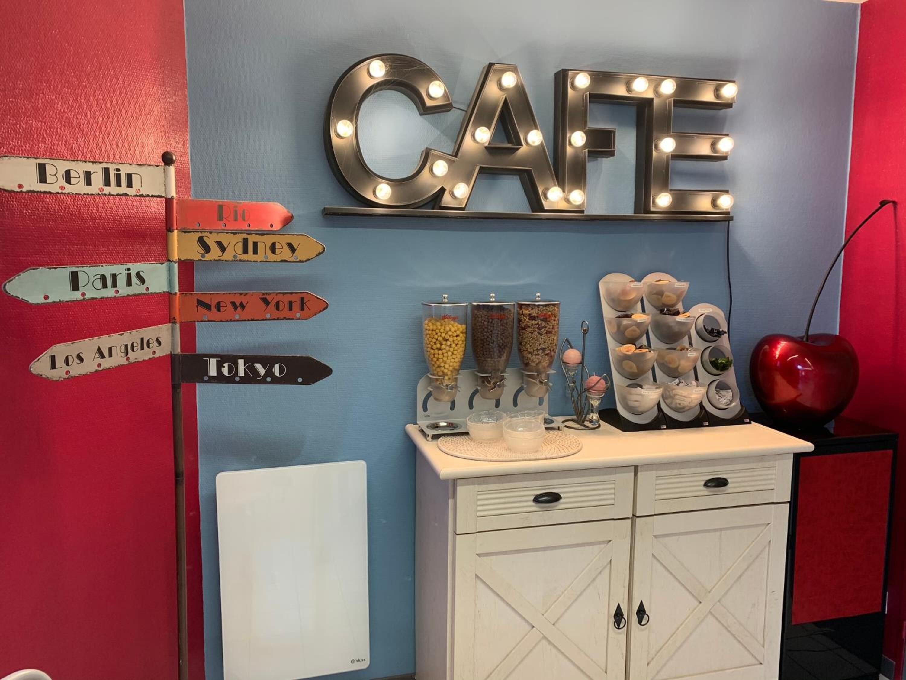Um café com uma placa listando cidades como Berlim, Sydney, Paris, Nova York, Los Angeles e Tóquio.