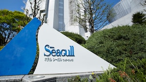Placa do hotel Seagull com um edifício moderno ao fundo.
