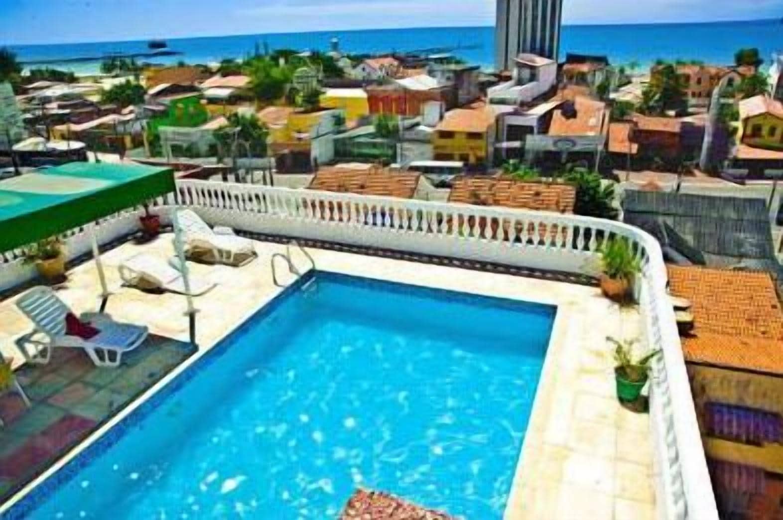 Piscina no terraço com vista para uma cidade costeira.