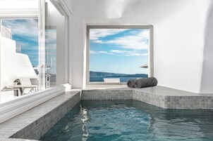 Piscina interior moderna com vista clara para o mar e interiores brancos.